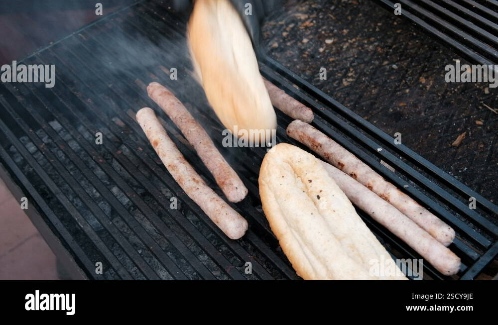 Fast food. A street cook in black gloves with the help of tongs lays a ...