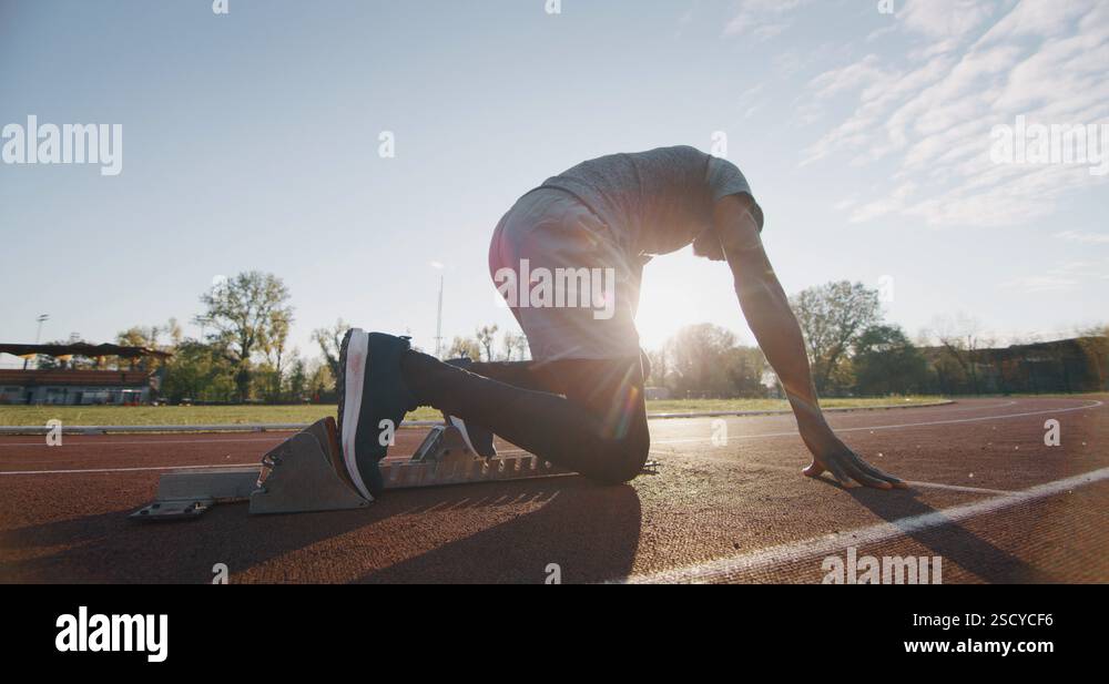 Slow motion of young african male athlete is launching off the start ...