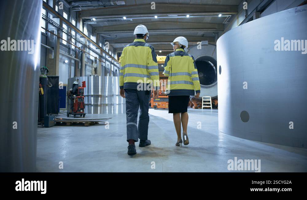 Two Heavy Industry Engineers Walk Through Pipe Manufacturing Factory ...