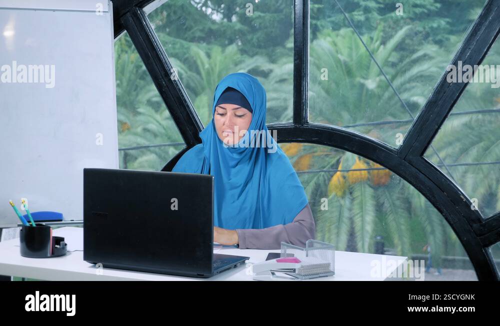 beautiful saudi business woman in hijab working in office using laptop ...