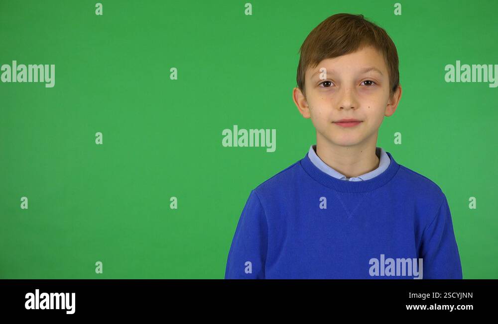 A young cute boy smiles at the camera - green screen studio Stock Video ...