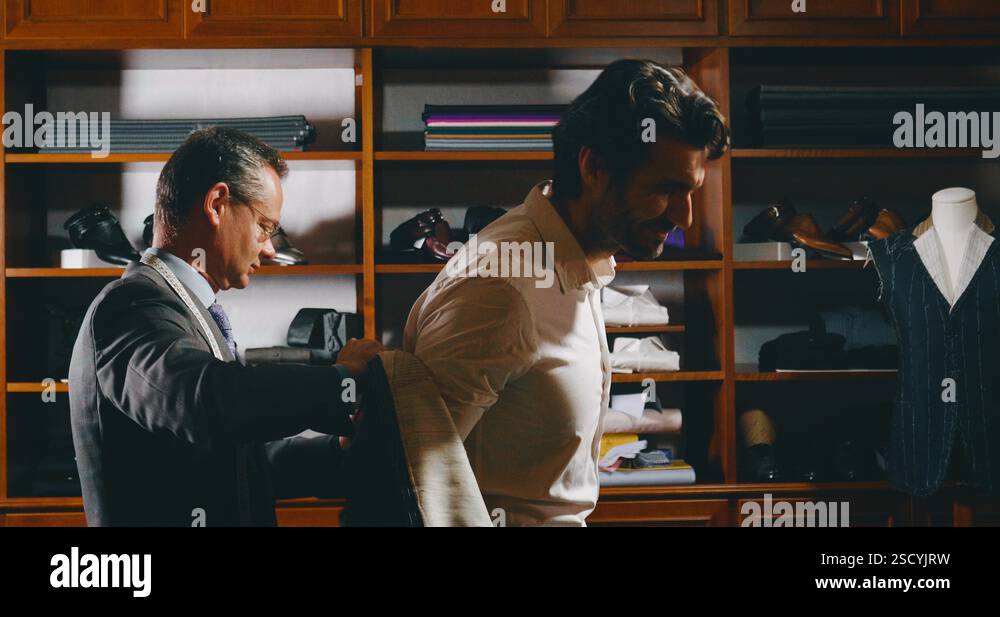 A tailor taking a measures of for a new handmade great quality suit in ...