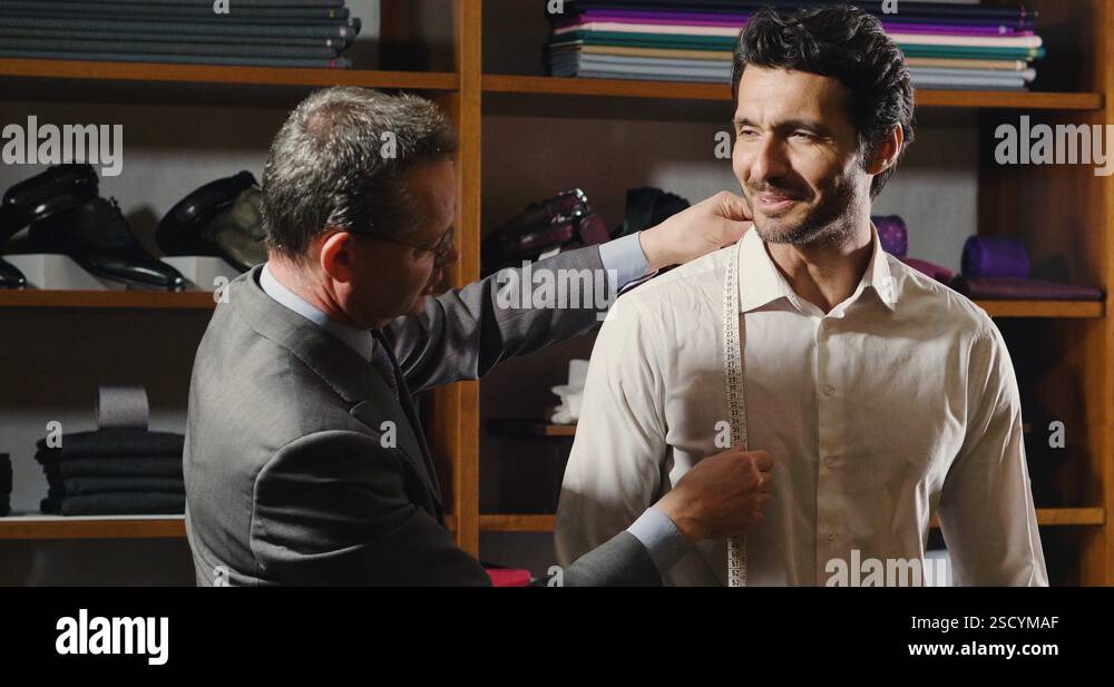 A tailor taking a measures of for a new handmade great quality suit in ...