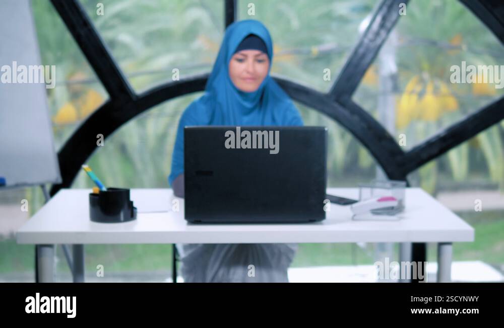 beautiful saudi business woman in hijab working in office using laptop ...