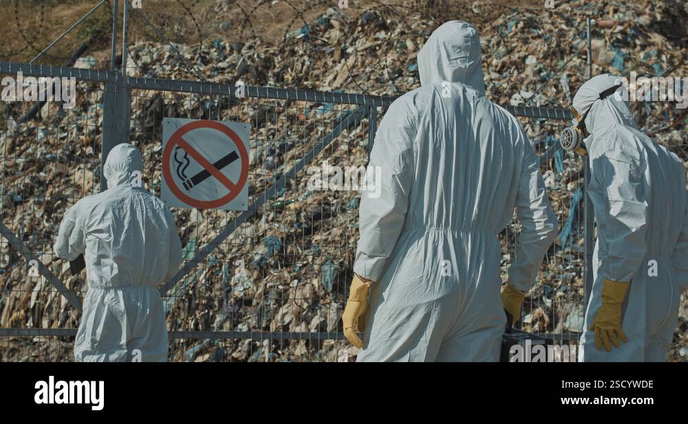 Ecology inspectors in chemical protection opening the gate and walking ...