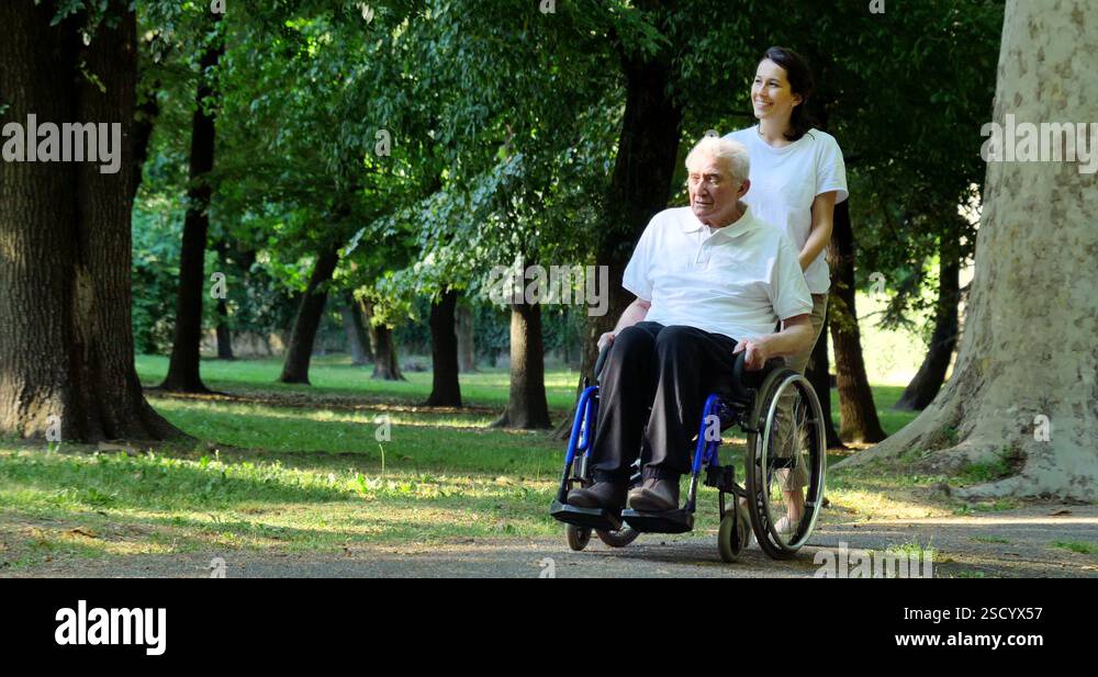 Granddaughter and grandfather in a wheelchair having fun to run in a ...