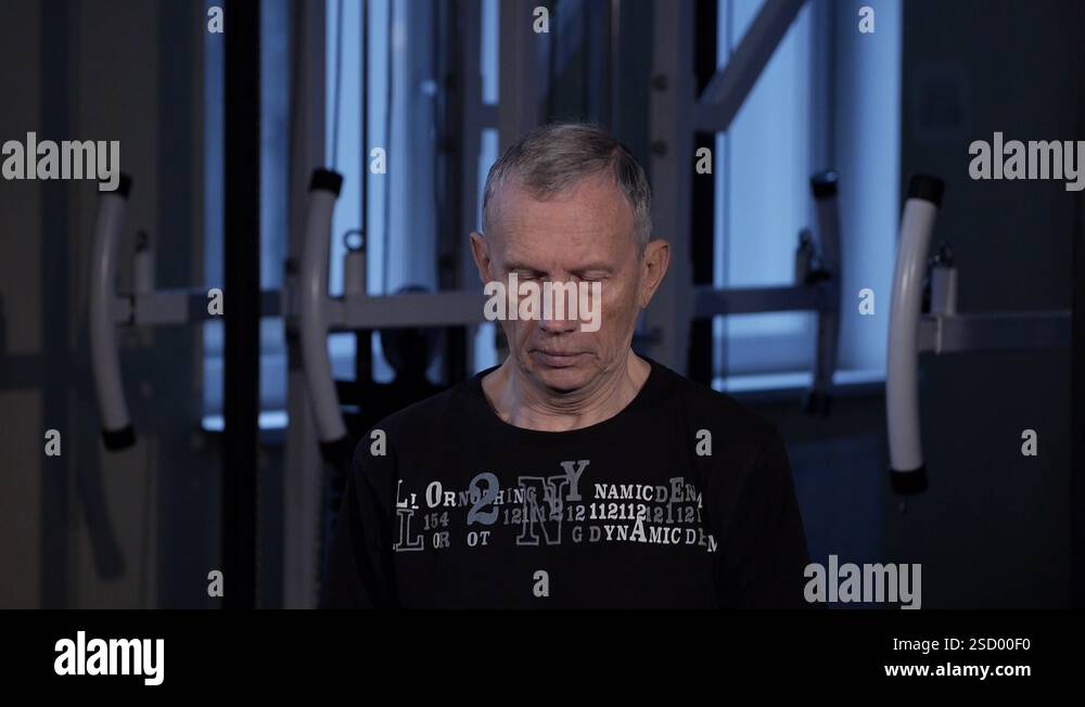 A man of the age performs joint gymnastics for the neck in the gym ...