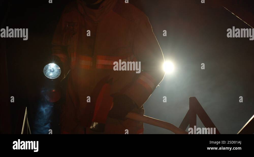 Fire Fighter scanning area for survivors with large flashlight and ...