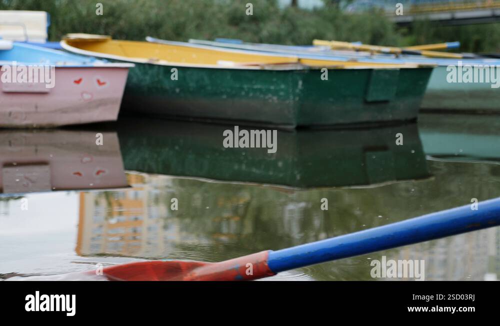 Wooden boat sailing near pier. Paddle rowing among wooden boats. Paddle ...