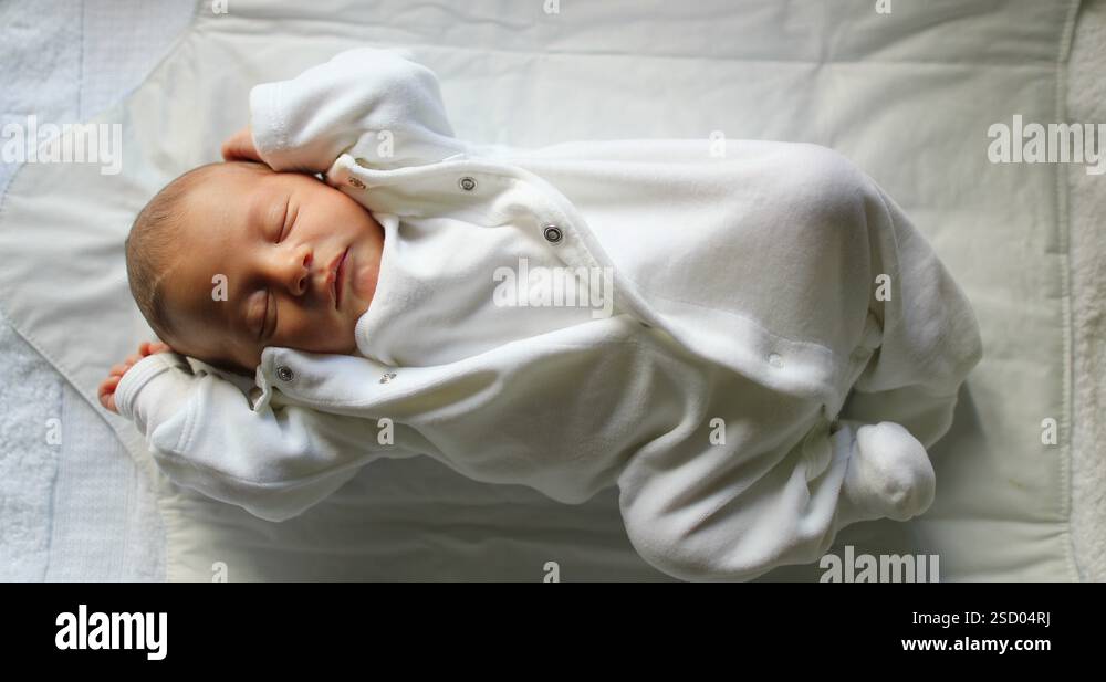 Newborn baby seen from above in vertical angle. Infant in first day of ...