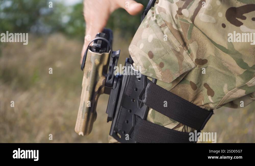 Military man takes the gun out of the holster and put in back Stock ...