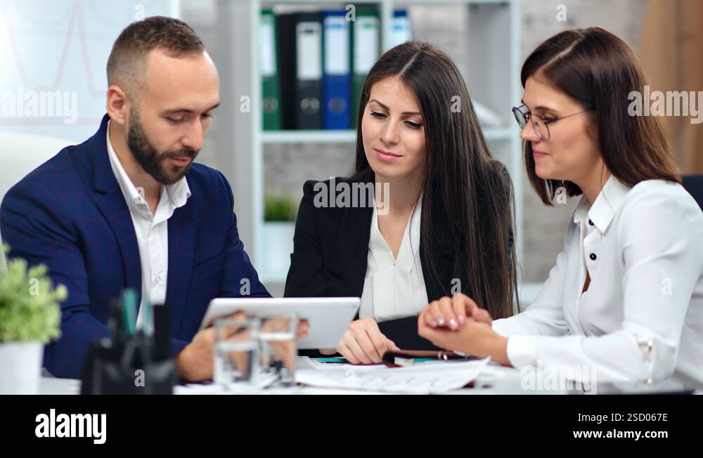 Two smiling female employee showing marketing researching data to male ...