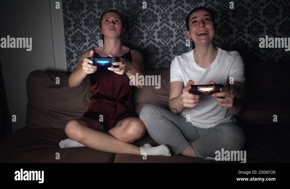 Pair of girls with great excitement compete in game on the console ...