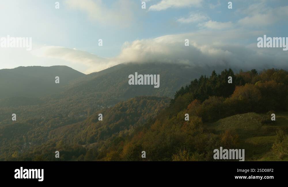 Colorful wooded mountain top valley hills in fall in a windy cloudy day ...