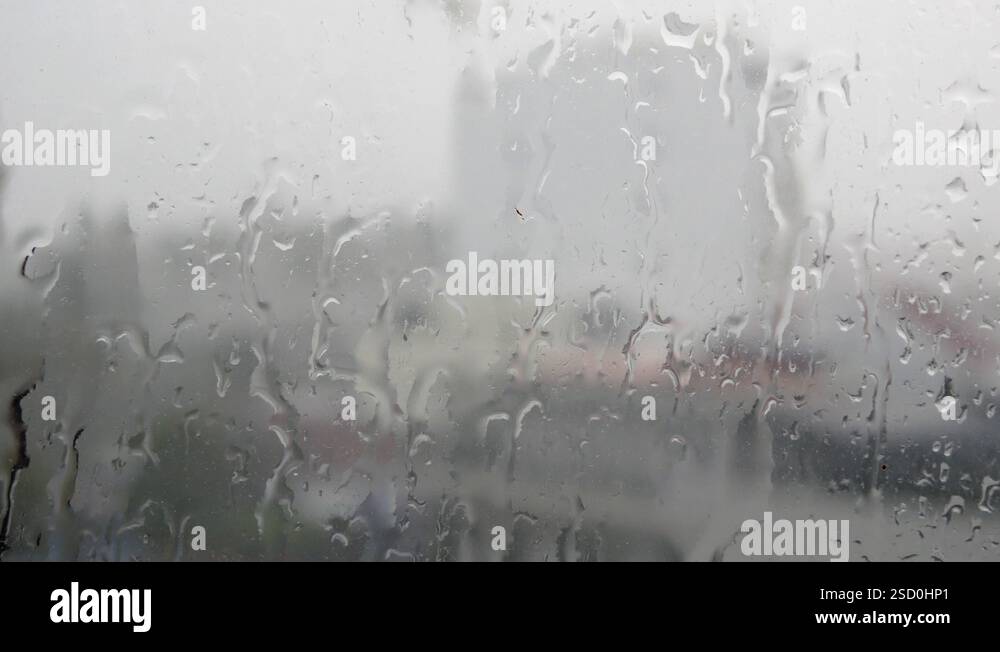 Strong rain water flushes against window glass and streaming down ...