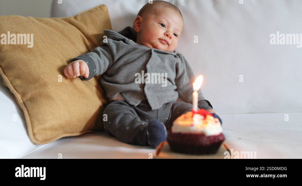 Celebrating baby first month of life with cupcake and candlelight Stock ...