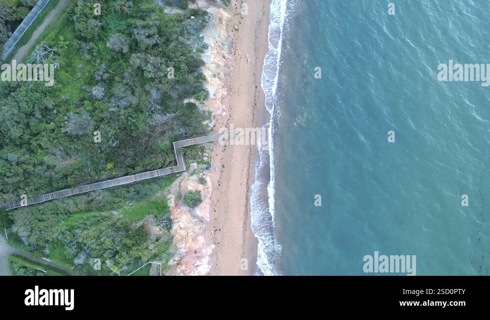 Forward flight looking down at cliffs over ocean coastline on ...