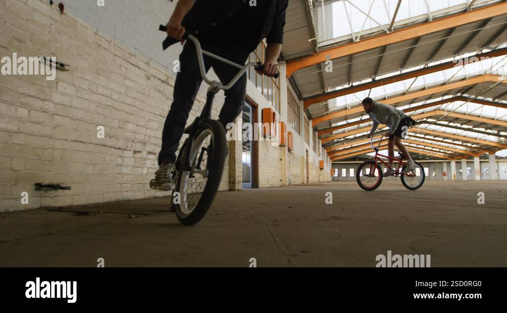 BMX riders in an empty warehouse riding on wall Stock Video Footage - Alamy