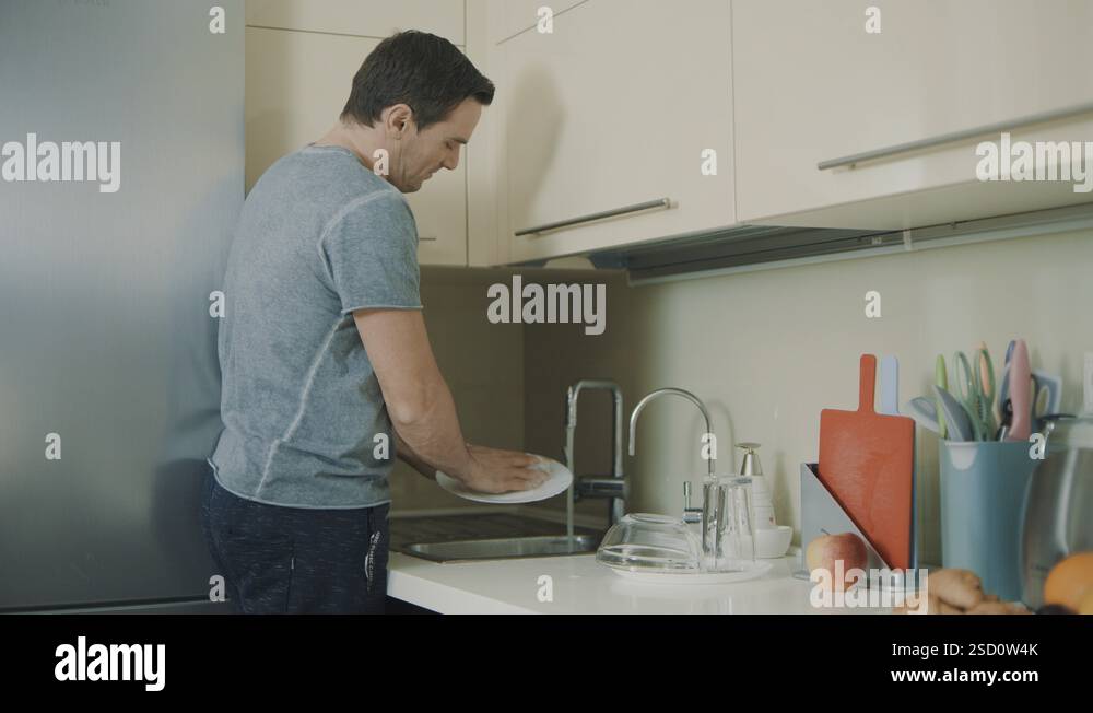 Cheerful husband doing household chores in slow motion Stock Video ...