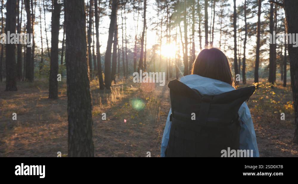 Back side view of young brunette female traveler with big tourist ...