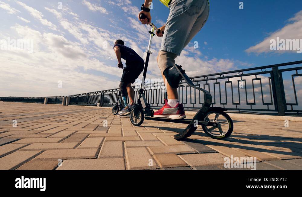 People with prosthetic legs are riding scooters along the road Stock ...
