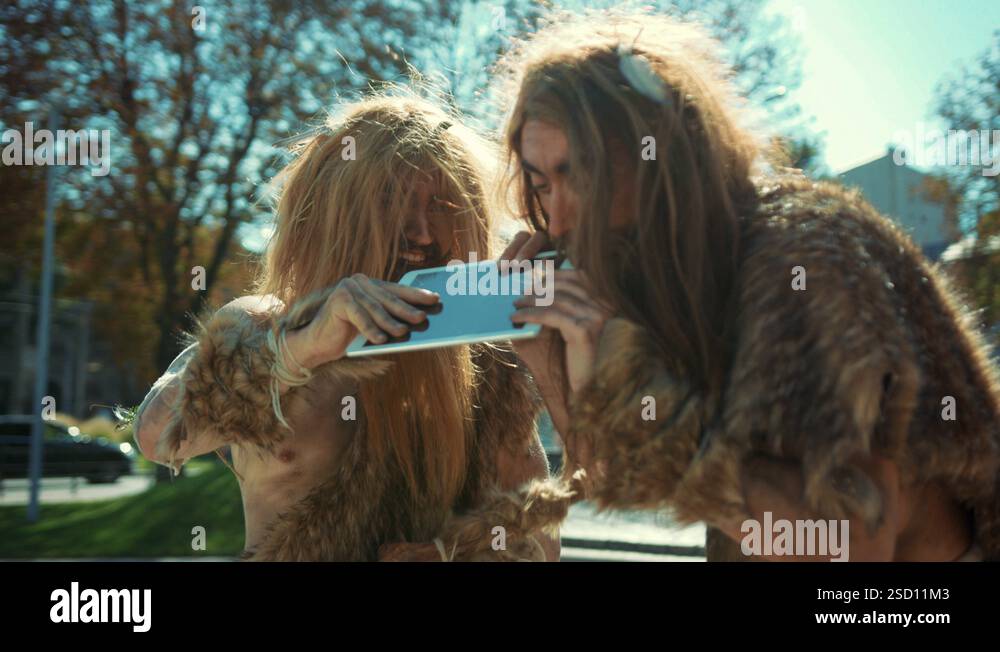 Cavemen of hunter-gatherers playing with tablet device trying to ...
