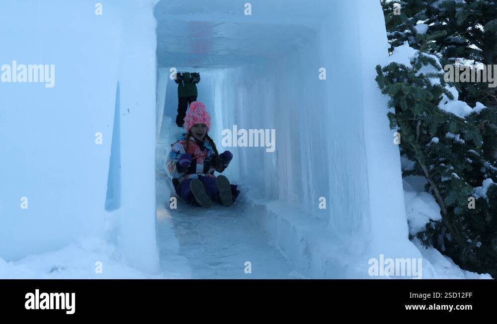 A family slides down a frozen ice slide in a cool ice castle in the winter Stock Video Footage ...