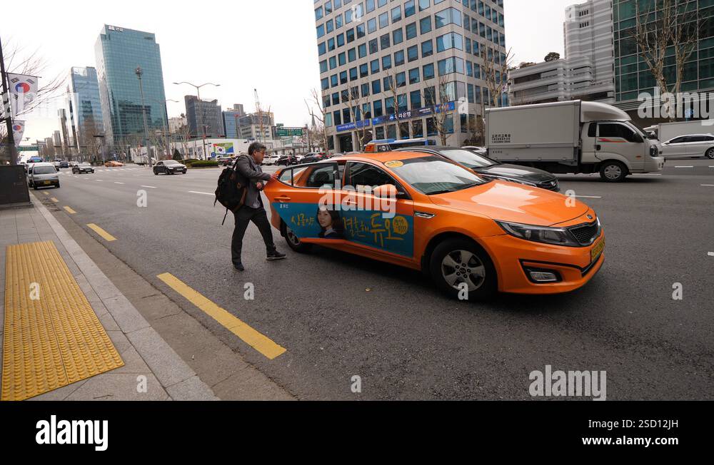 Man take taxi at street of Seoul, get in car and vehicle ride away ...