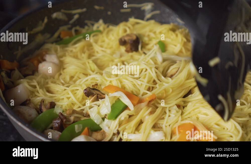 Lady frying stir-Fried Vegetables With Rice Noodles on a pan. Chinese ...