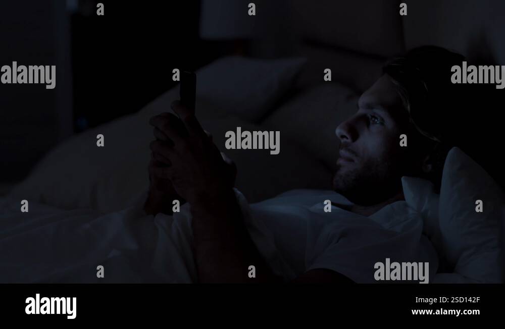 Man Lying in Bed and Using Phone at Night Stock Video Footage - Alamy