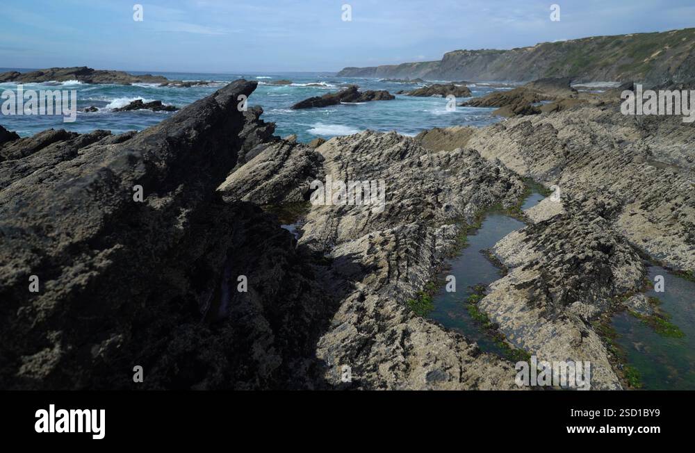 Reveal shot of a natural rocky wild coast beach with beautiful waves ...