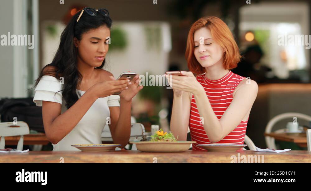 Diverse young women taking photo of food plate showing scren Stock ...