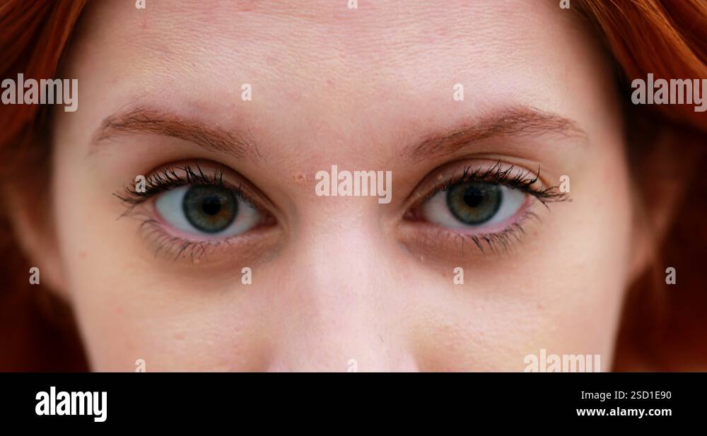 Young redhead woman opening eyes with shock. Closeup of girl opens eyes ...