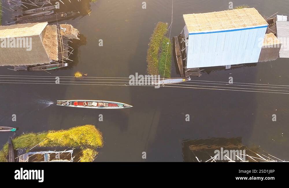 Canoe running trough the channel with traditional wooden houses and ...