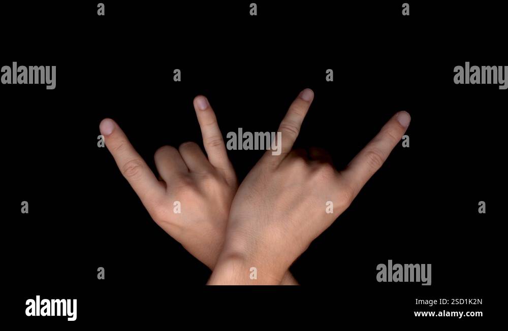 Criss cross rock and roll hand sign on a black chroma key screen ...