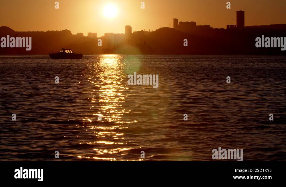 Sun ray reflected on water surface. Yellow sunrise above Vladivostok ...