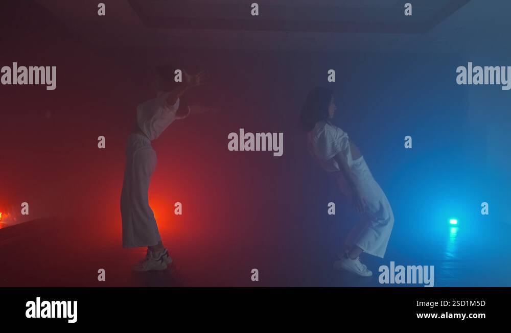 Girls in white dancing hip hop in smoky studio with blue and red ...