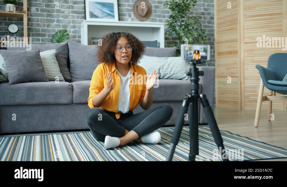 African American vlogger recording video with smartphone showing thumbs ...