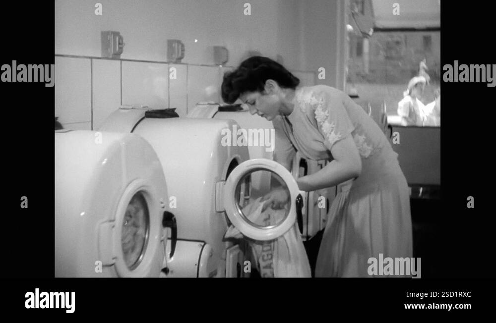 Woman In Public Laundromat Shop Putting Laundry Into Washing Machine ...