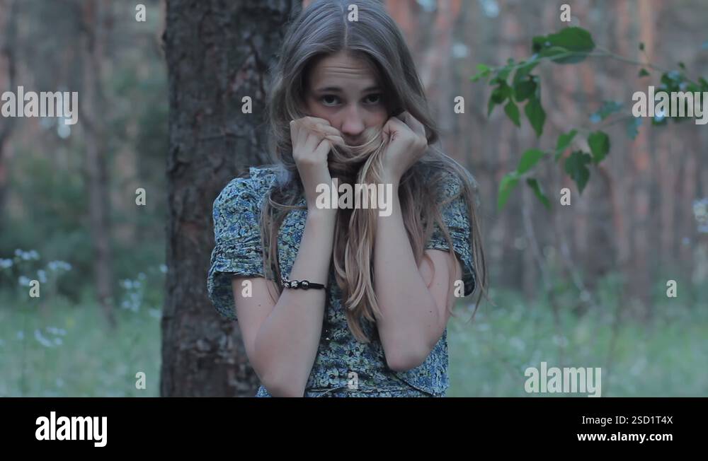 Haunted ghost girl hiding face in long hair gazing into camera in dark ...