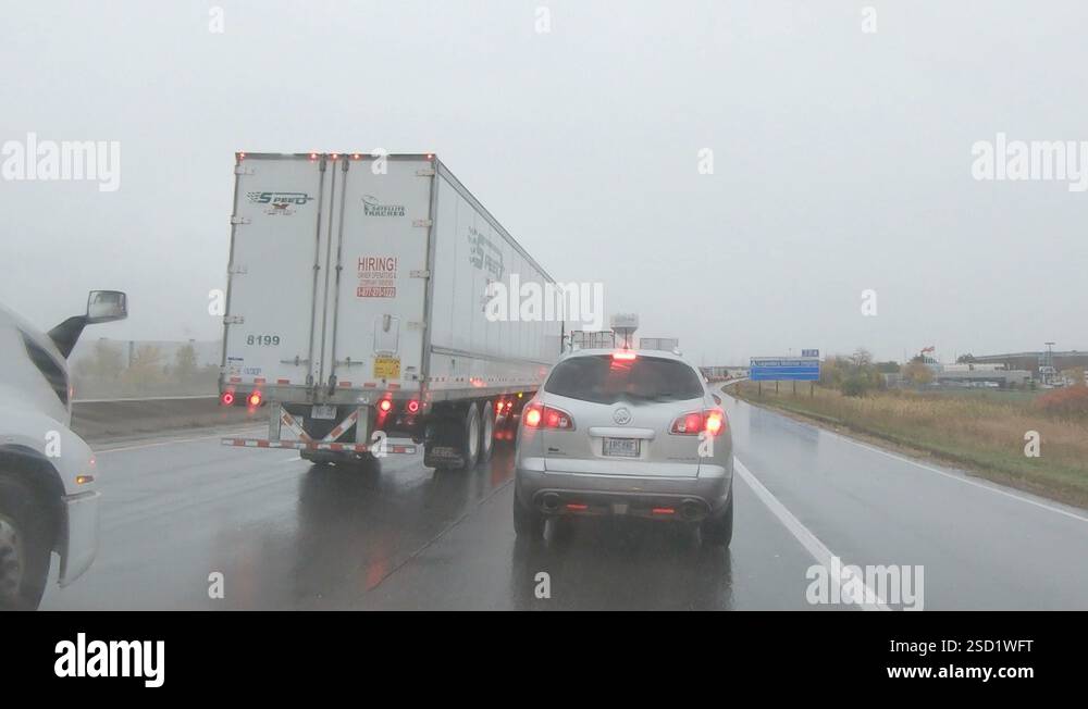 POV driving plate on wet highway in heavy rain with truck and car ...