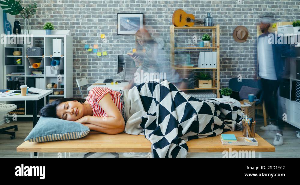 Zoom-in time lapse of female office worker sleeping on table in ...