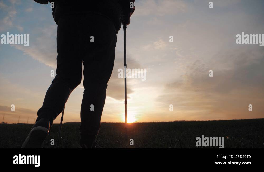 Silhouette hiker man tracking with backpack and trekking pole at sunset ...