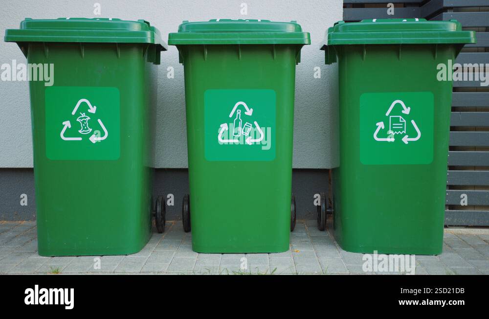 Green colored, plastic garbage bins, with different recycle logos on ...