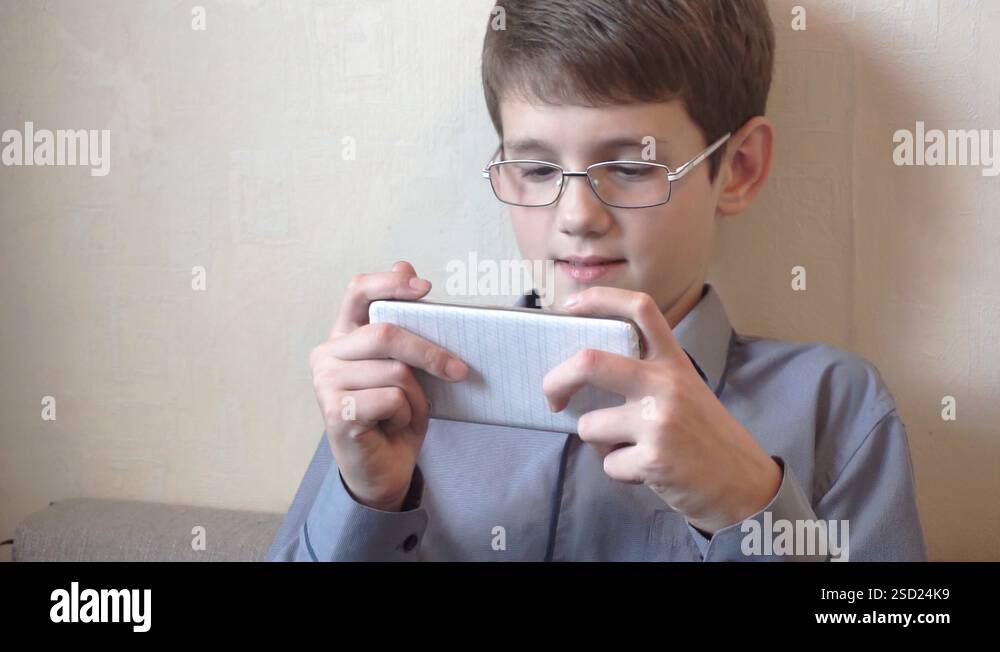 school-aged boy in glasses spends time using a smartphone Stock Video Footage - Alamy