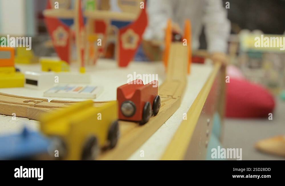 A boy is playing with a children's train. A boy plays on the railway ...