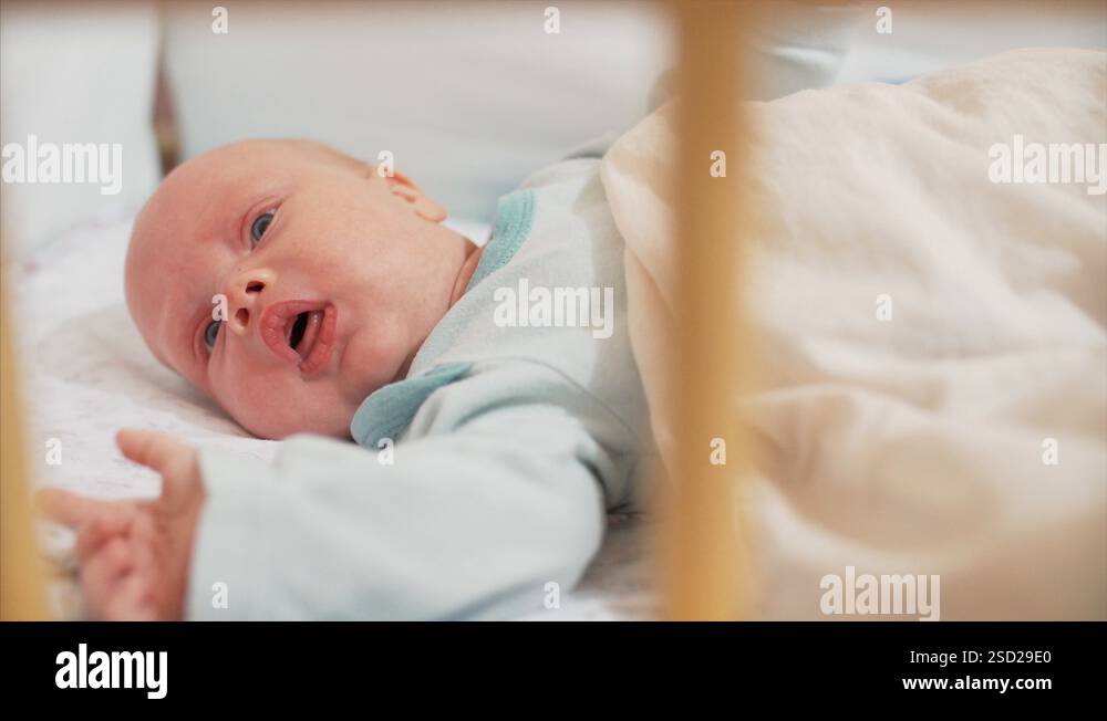 Sliding sideways: portrait of cute newborn boy laying in his bed Stock ...