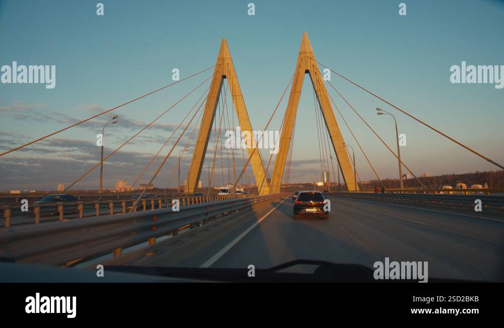 car drives under bridge pylons in letter M shape in evening Stock Video ...