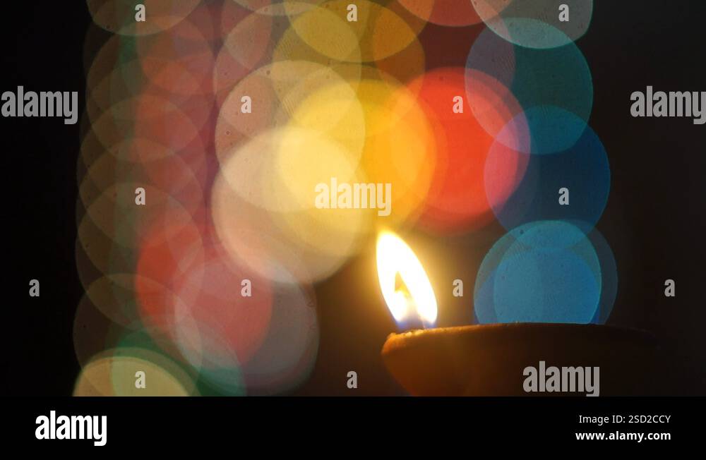 DIya burning with bokeh of lights behind it on the hindu festival of ...