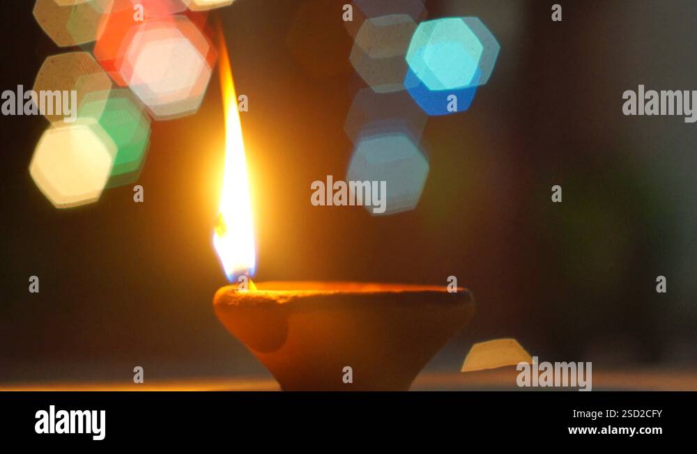 DIya burning with bokeh of lights behind it on the hindu festival of ...